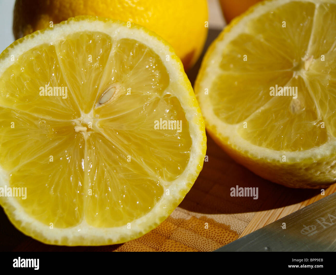 A freshly cut lemon on wooden chopping board Stock Photo - Alamy