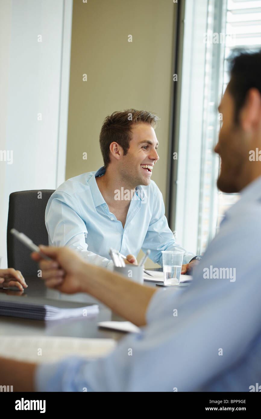 Smiling young man in business meeting Stock Photo - Alamy