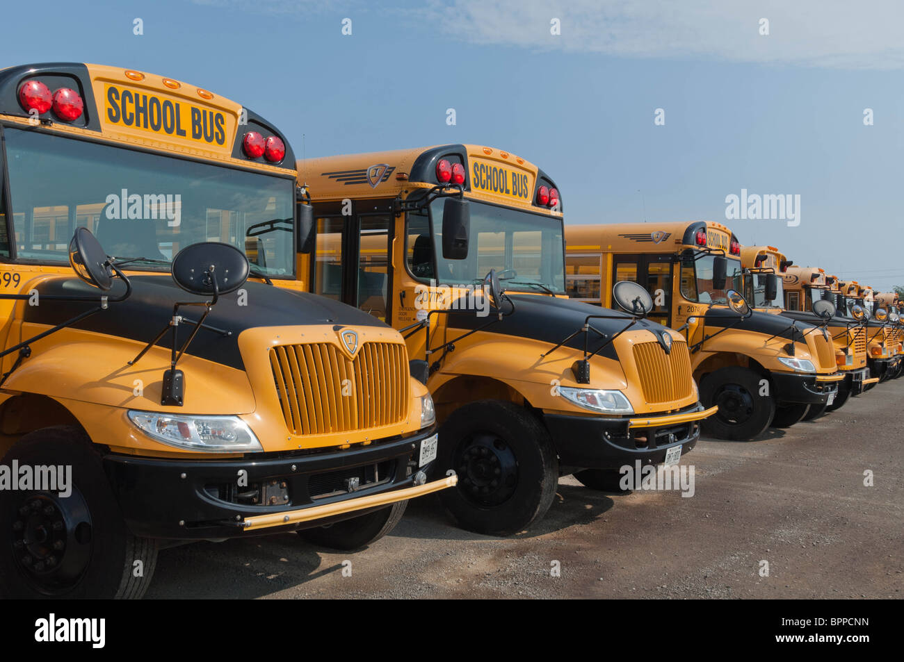 A fleet of shiny new school buses wait for another school year to begin ...