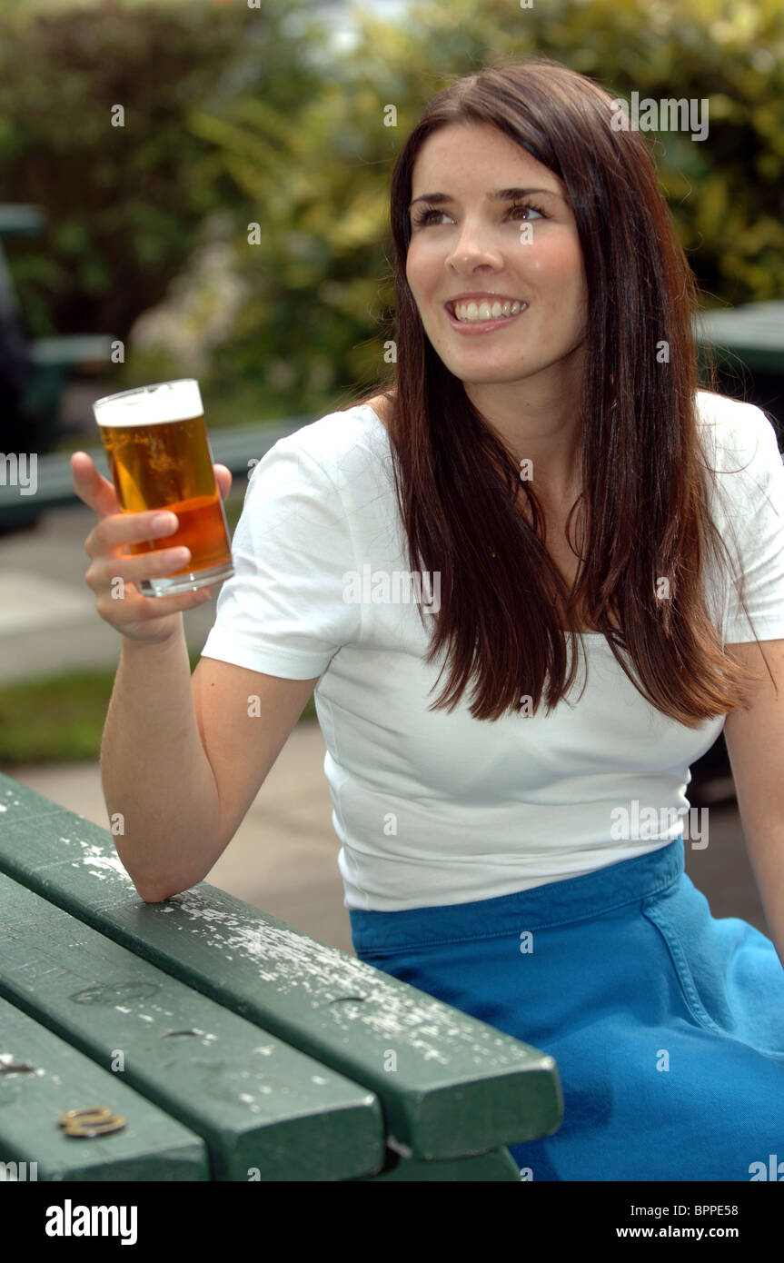 Attractive sat in a beer garden holding a drink Stock Photo - Alamy