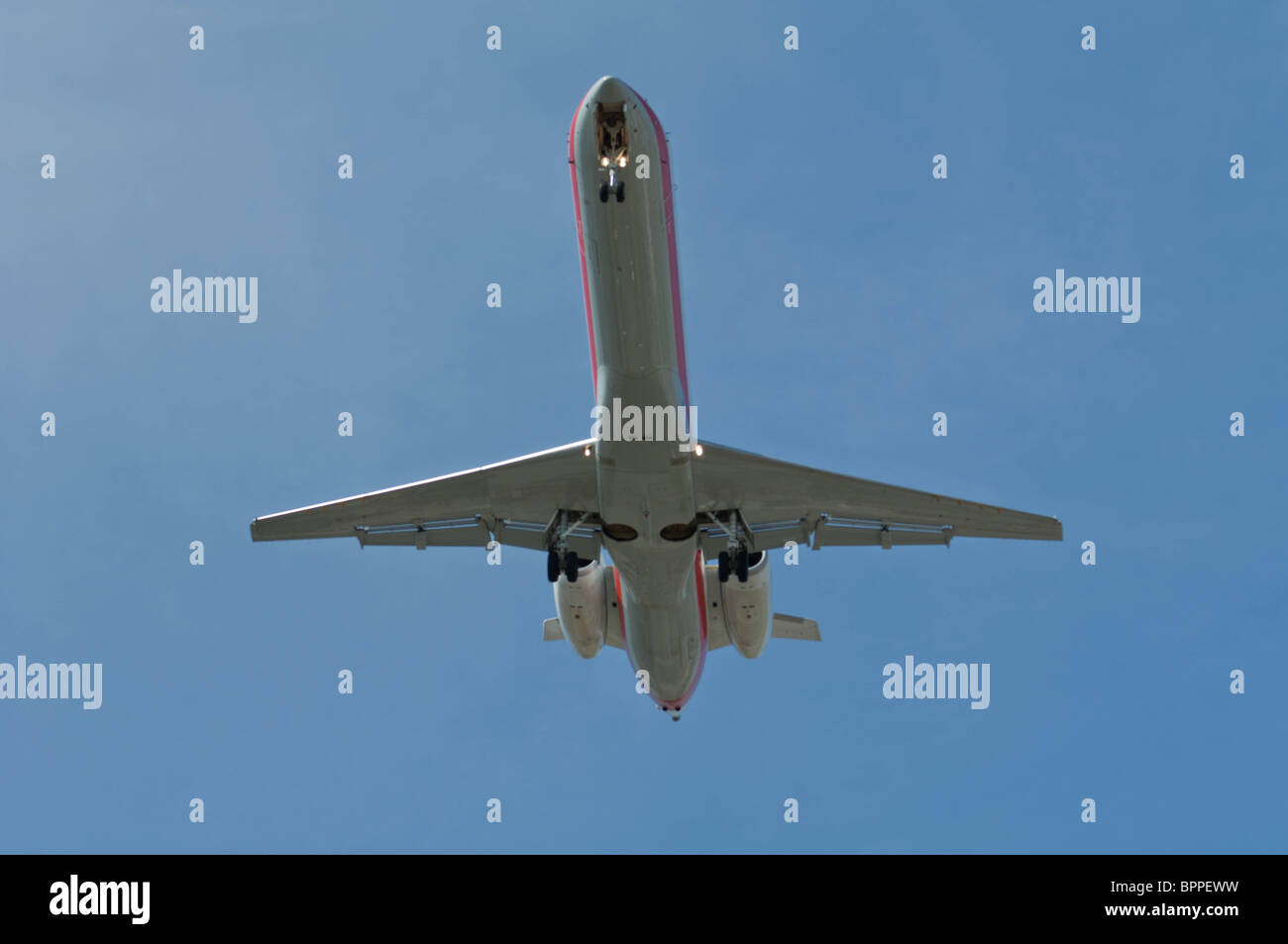 Underside of a passenger jet on a landing approach to a runway with ...