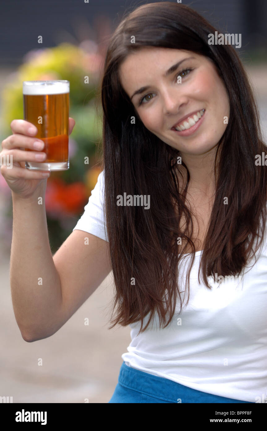 Girl holding beer in beer garden Stock Photo - Alamy
