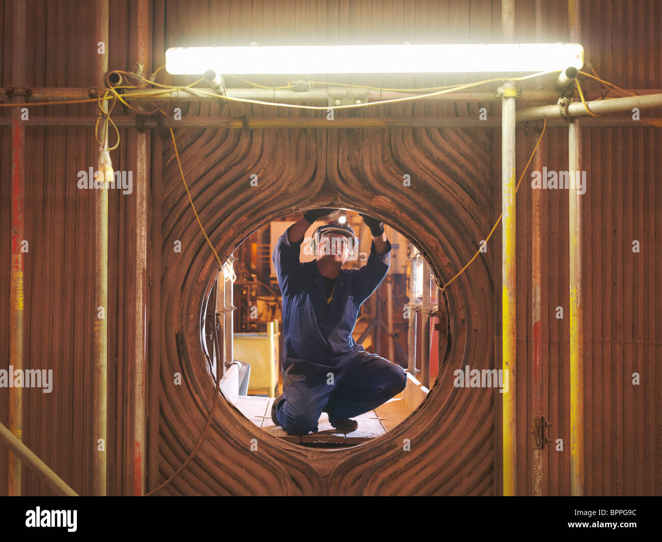 Worker repairing a furnace Stock Photo - Alamy