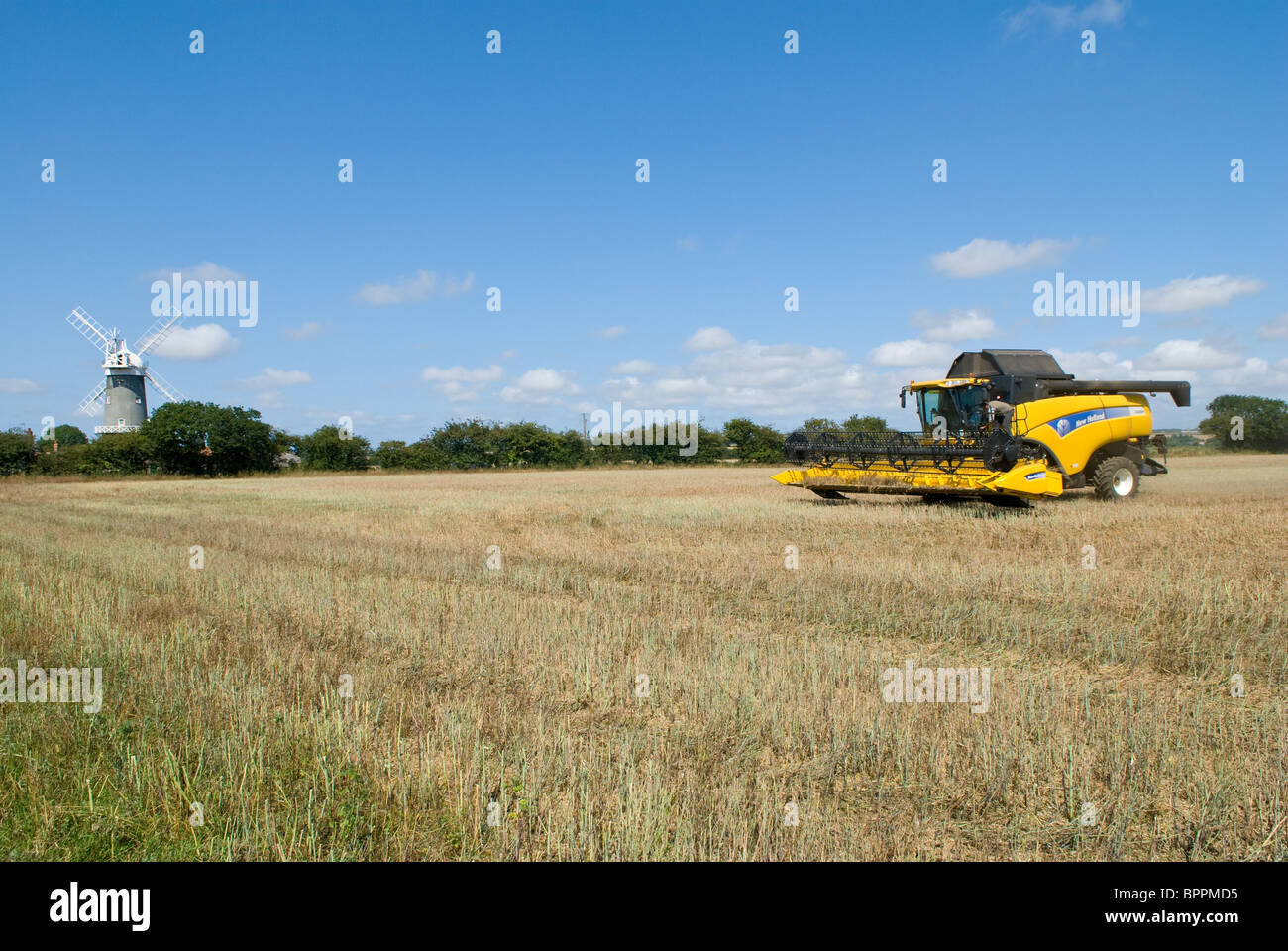 New Holland Combined harvester harvesting with Bircham Windmill in the ...
