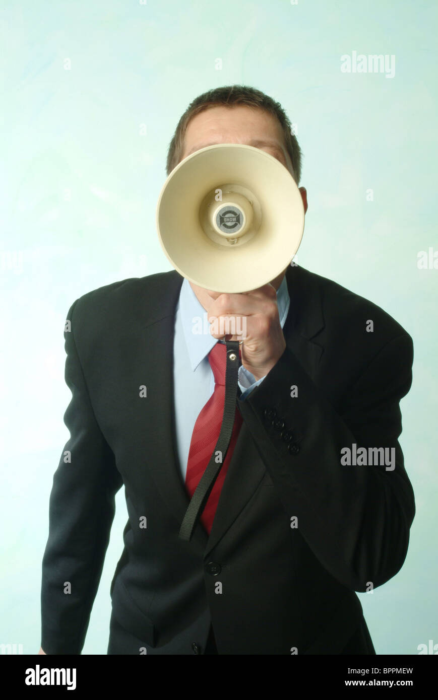 Man in a suit speaking through a megaphone Stock Photo - Alamy