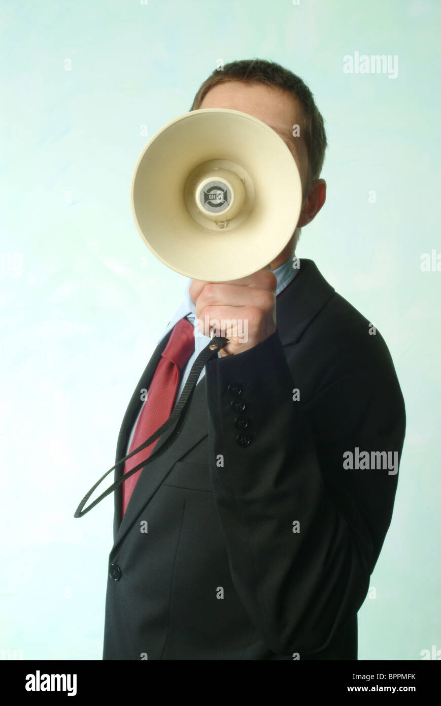 Man in a suit speaking through a megaphone Stock Photo - Alamy