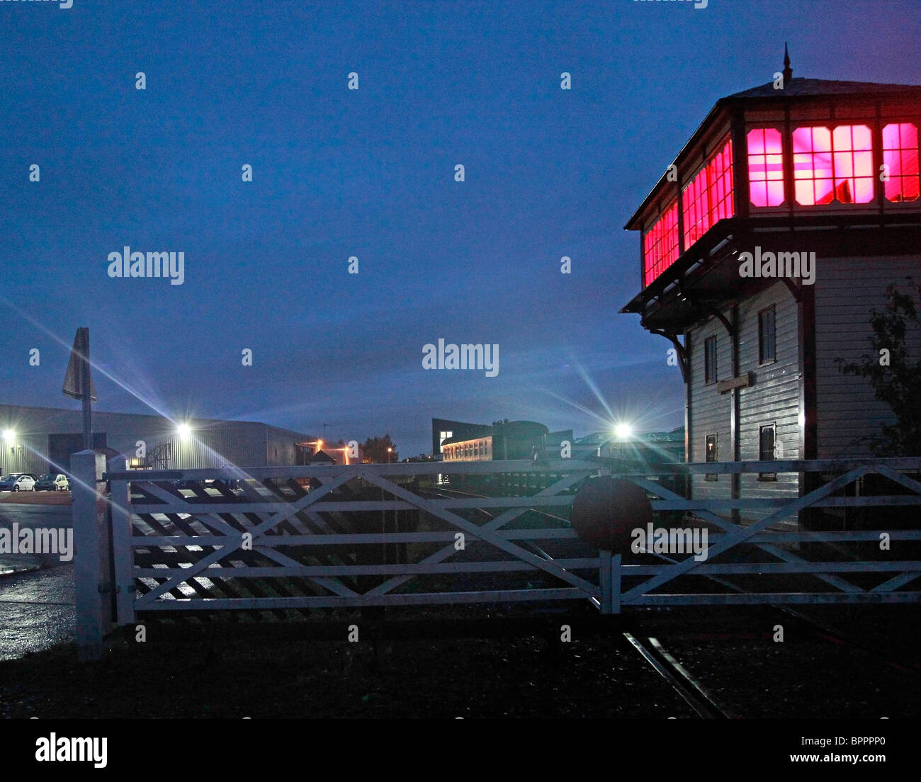 An old fashioned railway signal box and level crossing on a rainy night ...