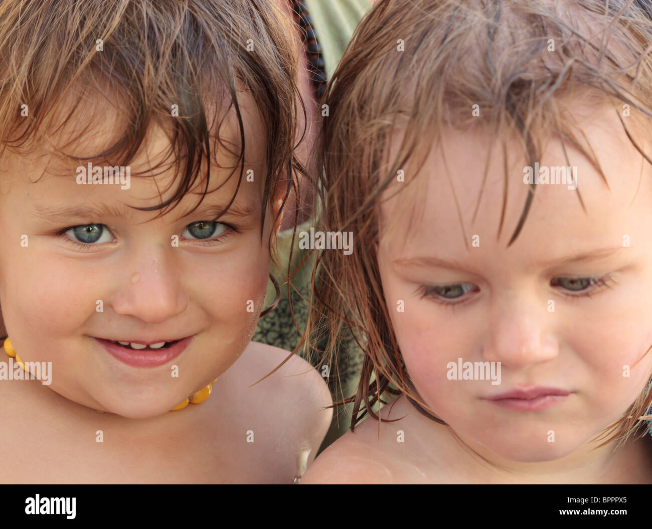 Two two year old girls, one happy, one sad Stock Photo - Alamy