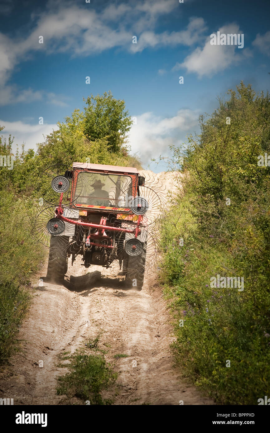Peasant driving a tractor in the countryside Stock Photo - Alamy