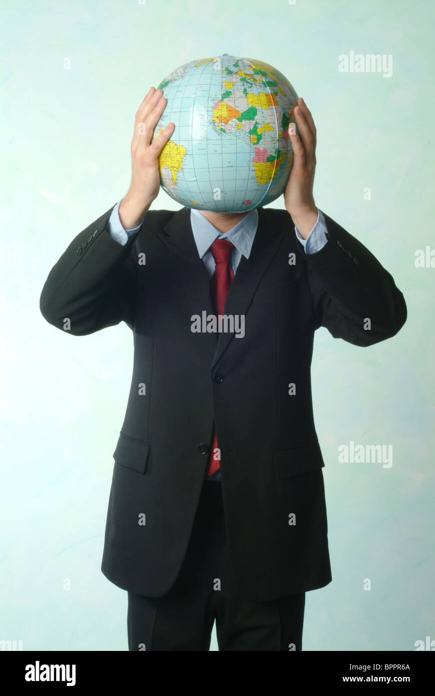 A man holding a globe to his head Stock Photo - Alamy