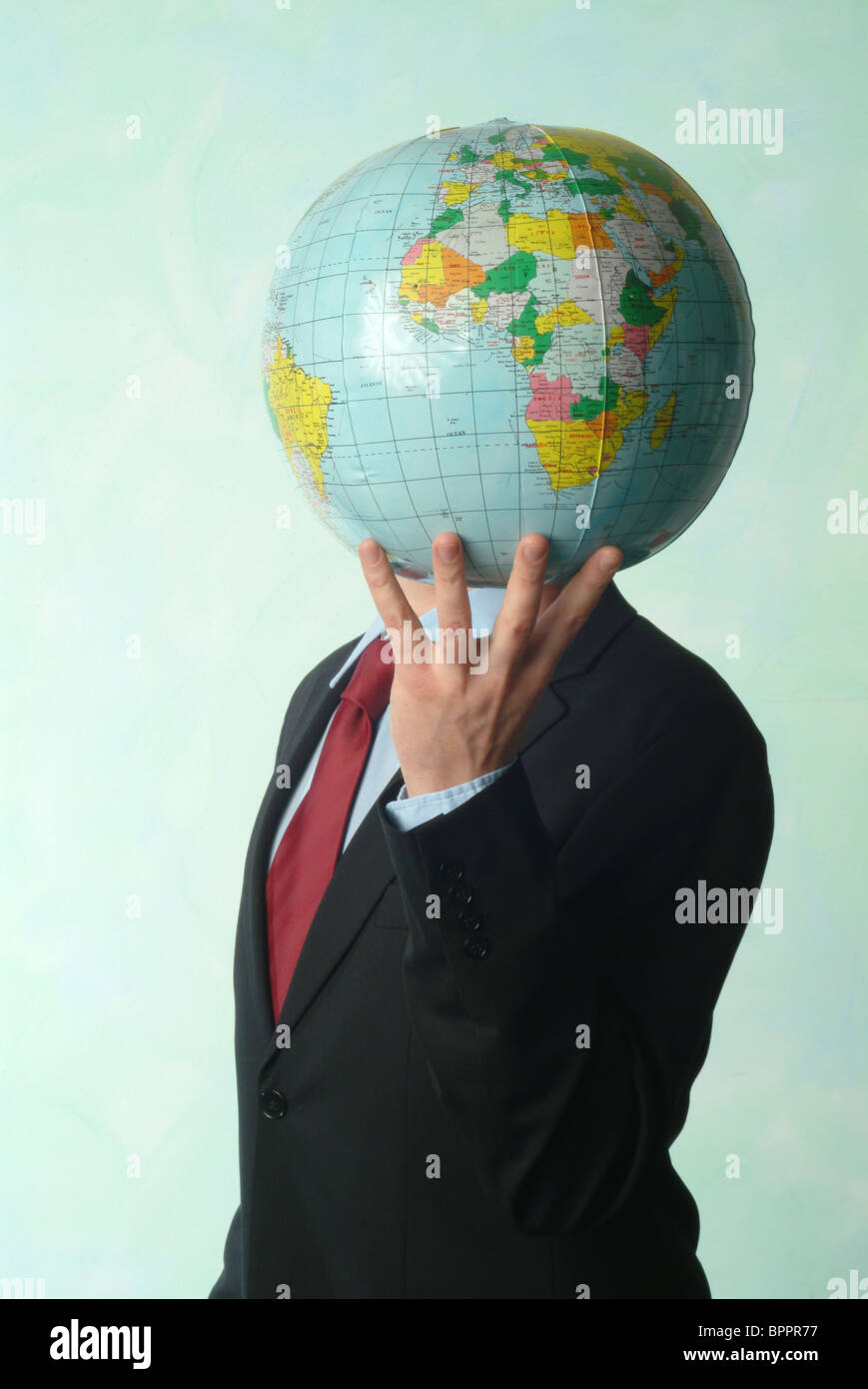 A man holding a globe to his head Stock Photo - Alamy