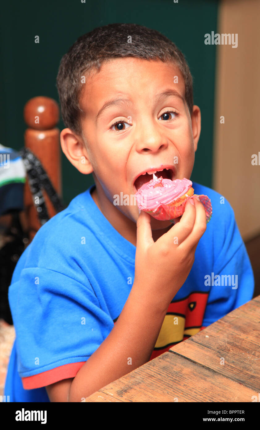 Boy eating a fairy cake Stock Photo - Alamy