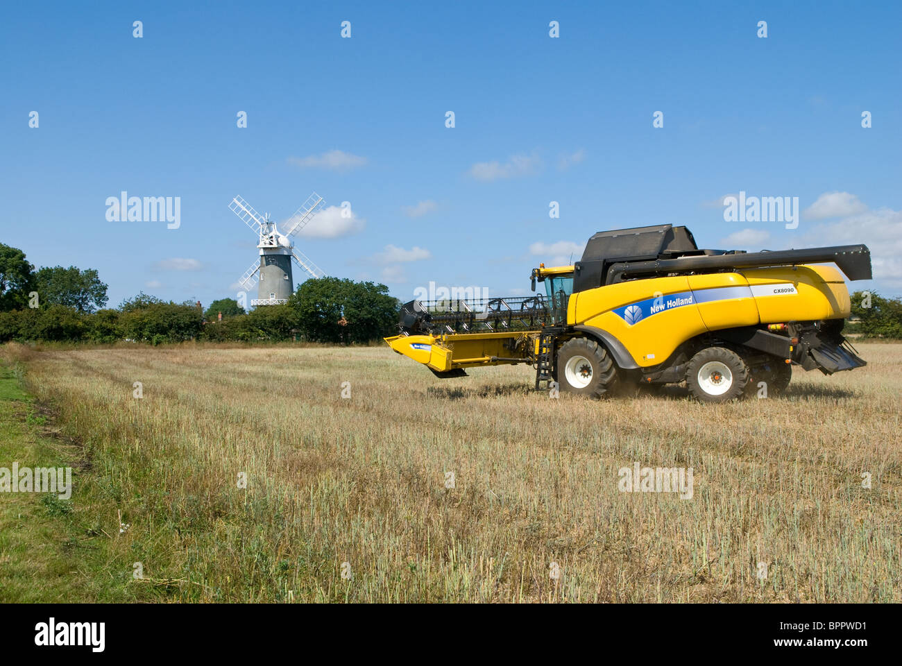 New Holland Combined harvester harvesting with Bircham Windmill in the ...