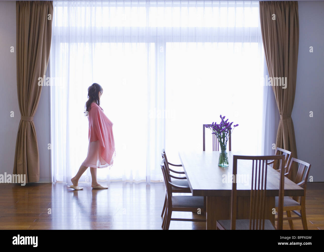 Woman standing by the window Stock Photo - Alamy