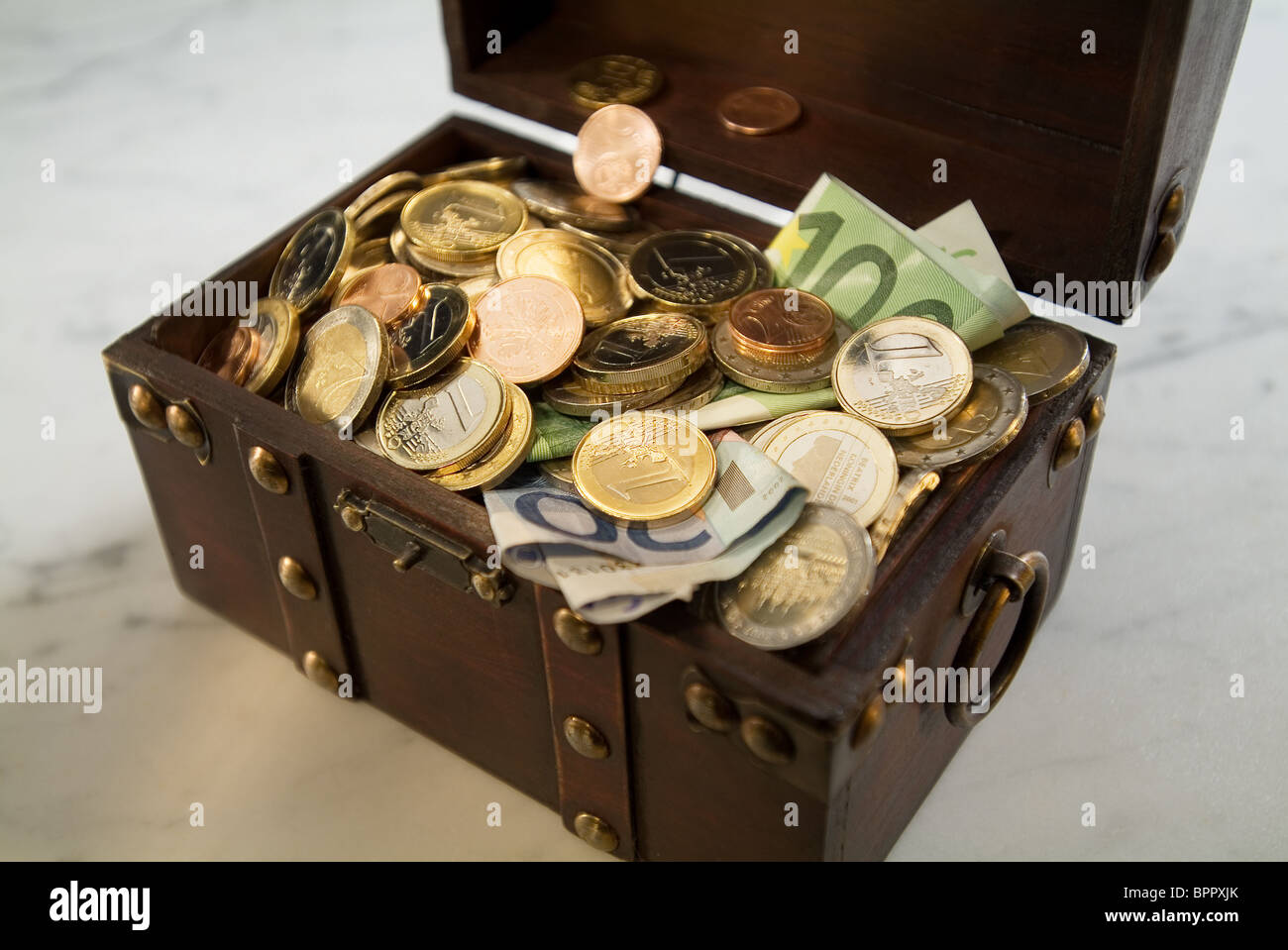A treasure chest filled with money Stock Photo - Alamy