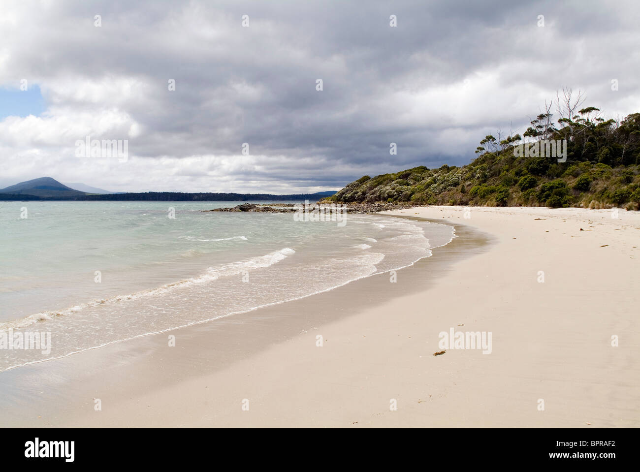 Wide bright beach with lapping waves Stock Photo - Alamy