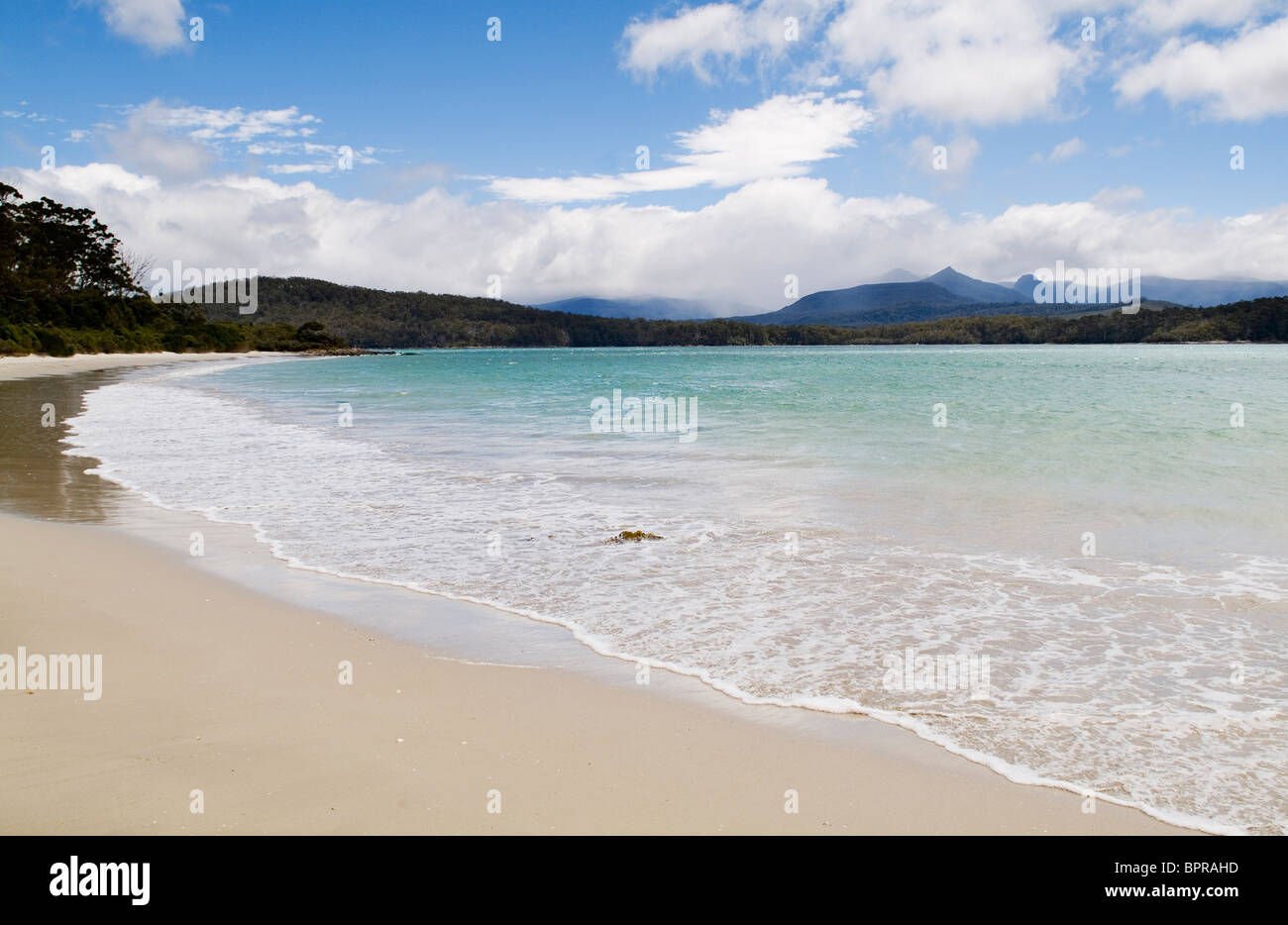 Wide bright beach with lapping waves Stock Photo - Alamy