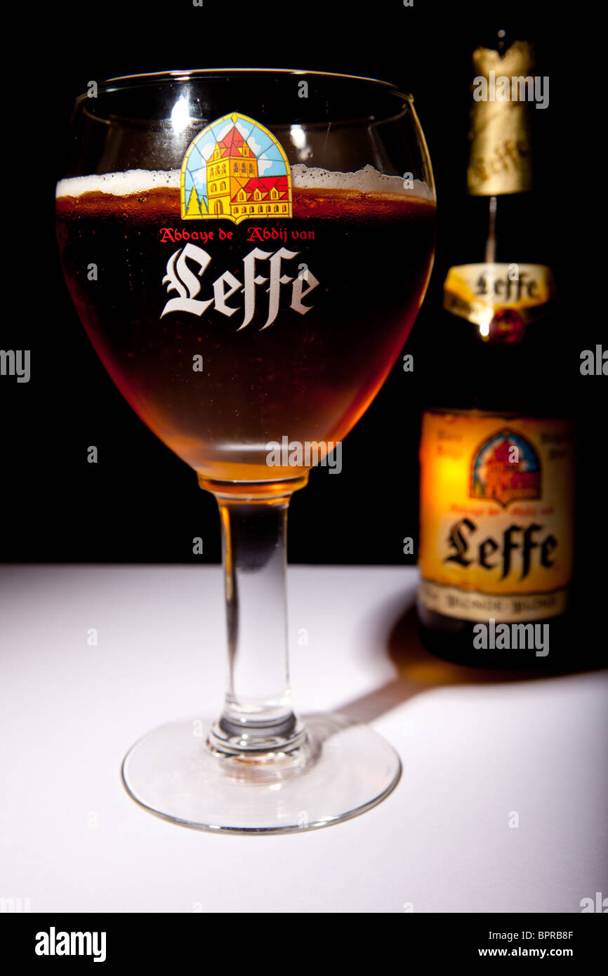 A glass of Leffe Belgian beer shot in the studio against an amber ...