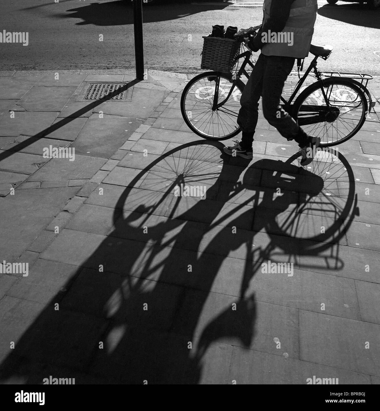 Shadows of a bicycle's wheels and its rider spread across a London ...