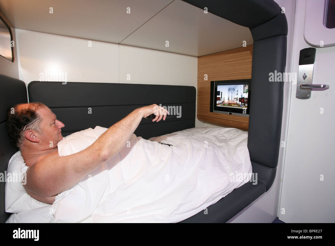 Image shows a man staying at Yotel, a budget hotel made of tiny cabins ...
