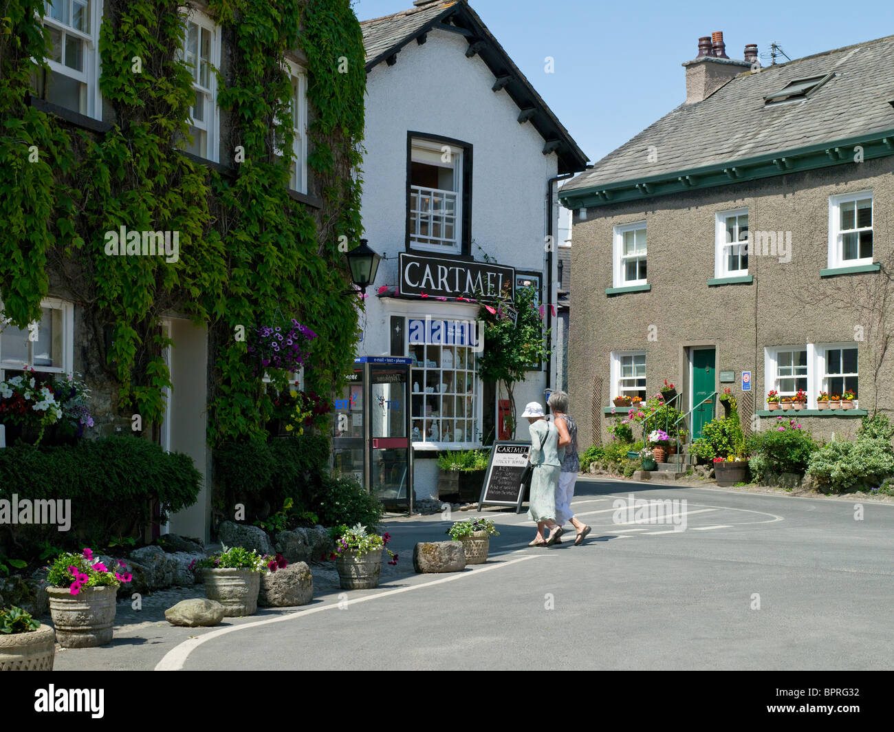People outside Cartmel village shop store in summer Devonshire Square ...