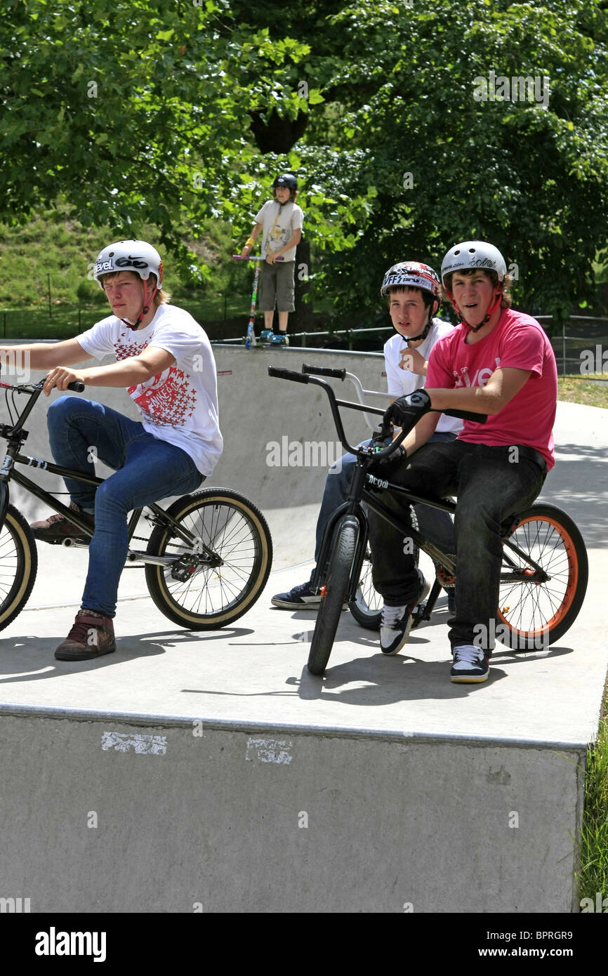 Group of teenage boys riding bmx bikes hang out with their friends at a ...