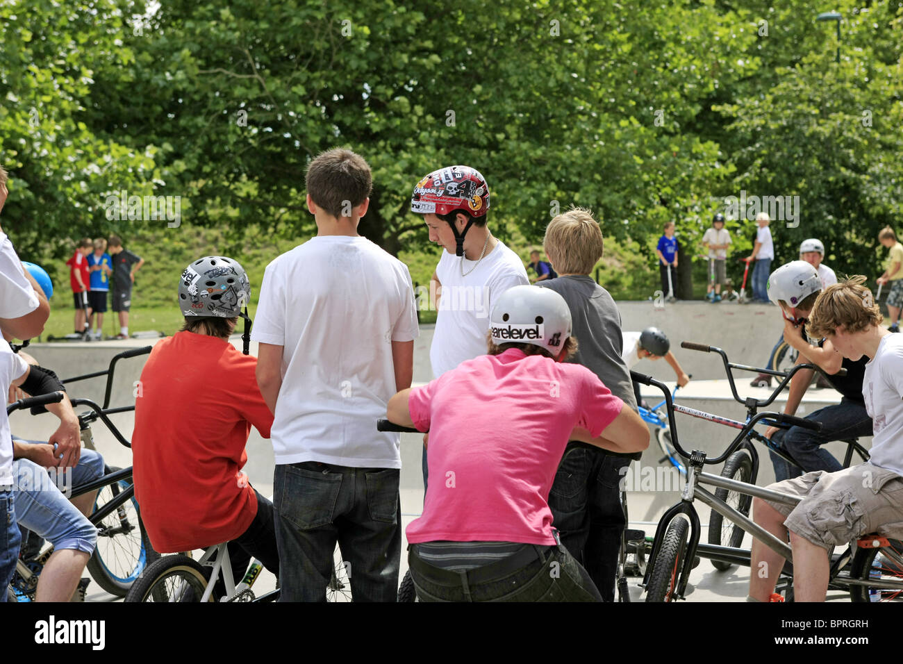 Group of teenage boys riding bmx bikes hang out with their friends at a ...