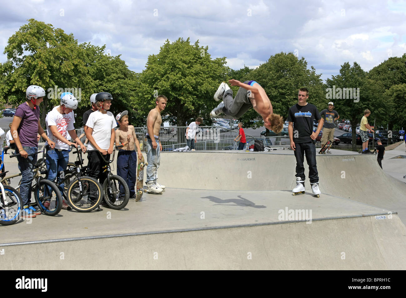 Teenage boy wearing roller-blades performs daredevil stunts in front of ...