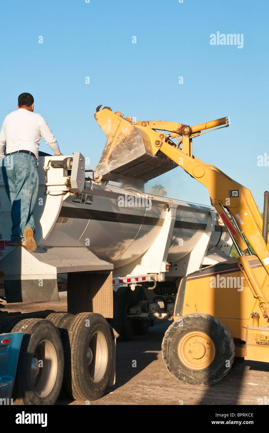 A backhoe is being used to remove debris from the demolition of an old ...