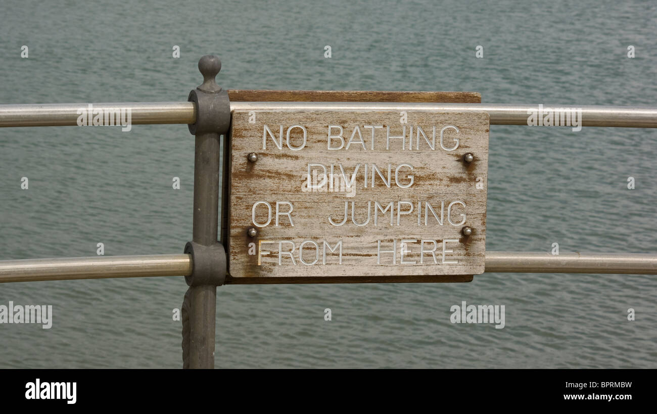 Wooden No bathing, diving or jumping sign attached to a railing on the ...