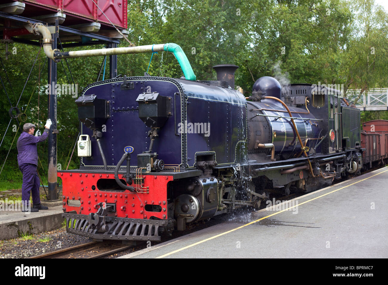Steam train at a station platform being filled with water Stock Photo ...