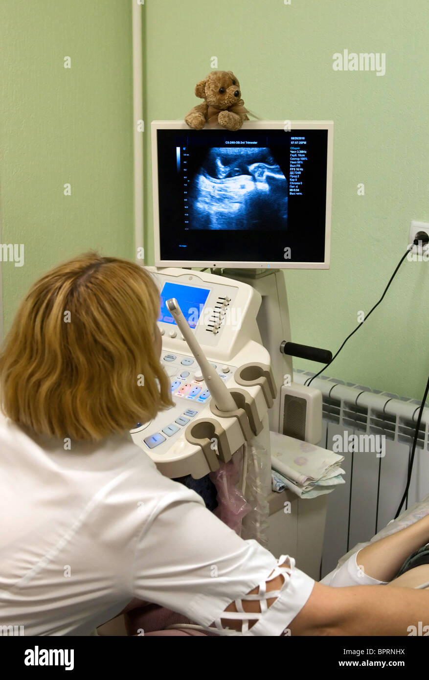 Obstetrician examining pregnant belly by ultrasonic scan Stock Photo ...