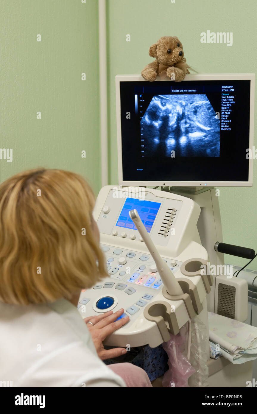 Obstetrician examining pregnant belly by ultrasonic scan Stock Photo ...