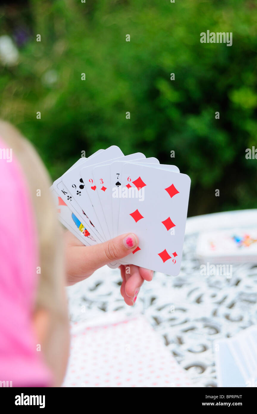 Young blond girl playing cards Stock Photo - Alamy