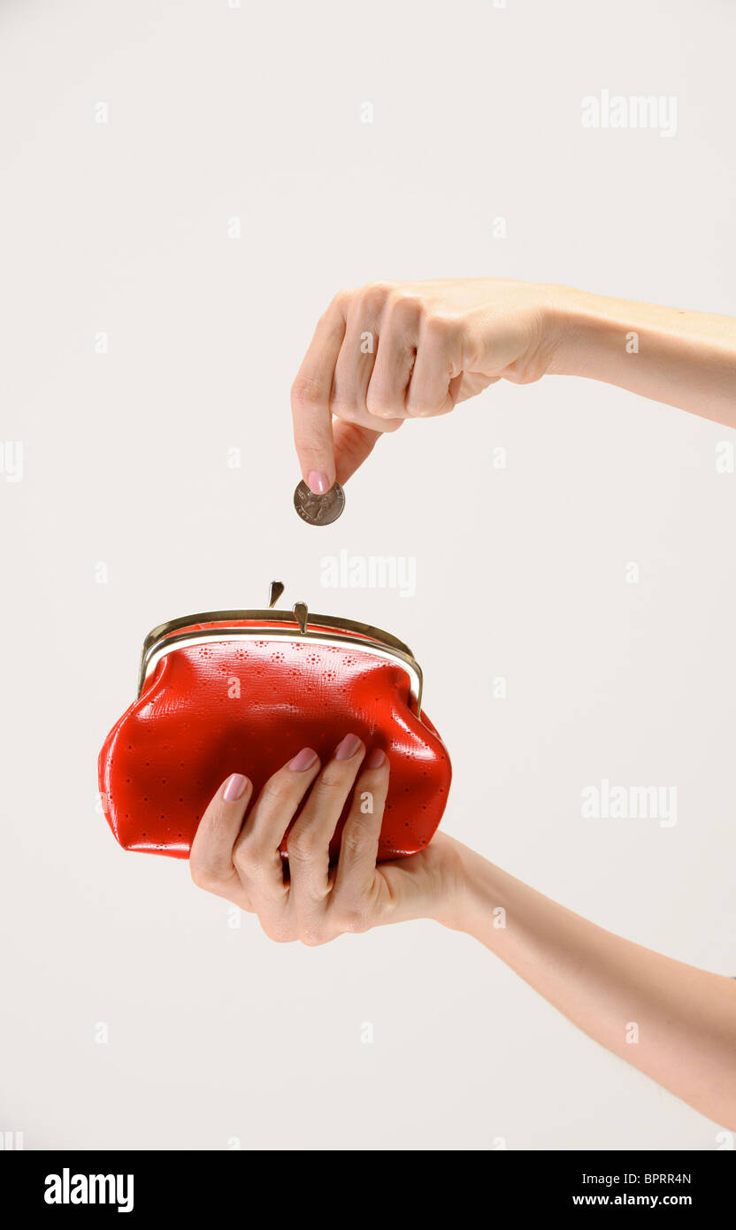 woman's hands put coin into big red purse Stock Photo - Alamy
