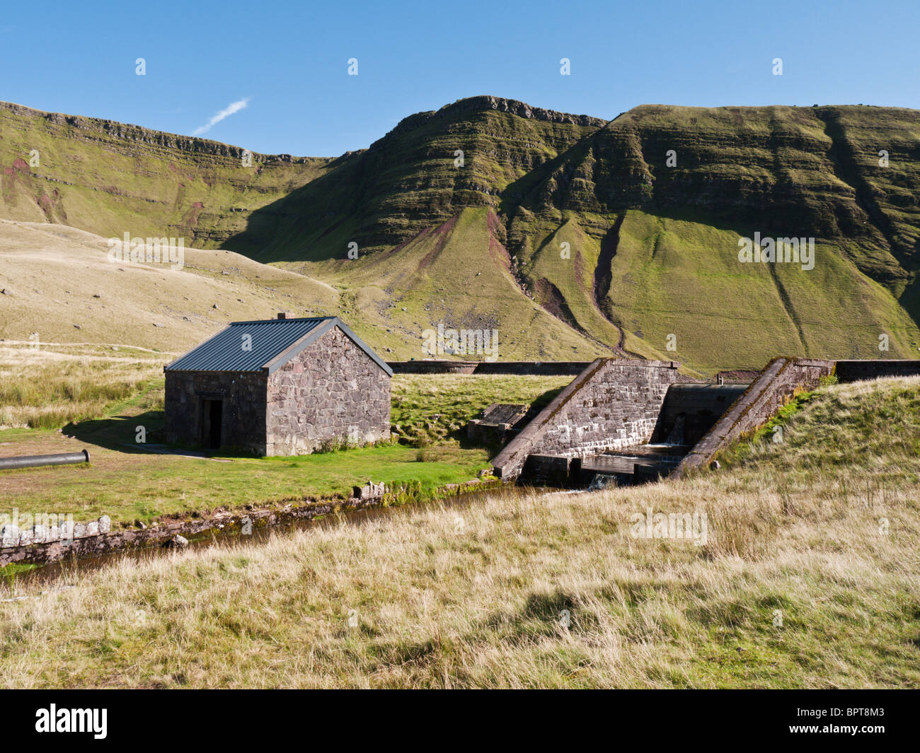 The bothy and dam at Llyn y Fan Fach, beneath Bannau Sir Gaer in the ...