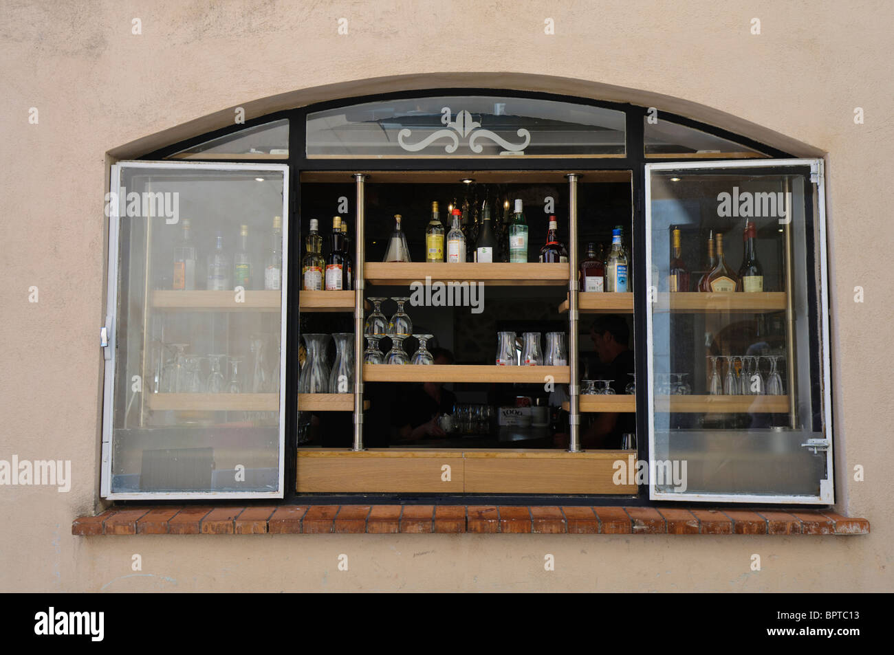 Open window of a bar, with shelves of drinks and glasses Stock Photo ...