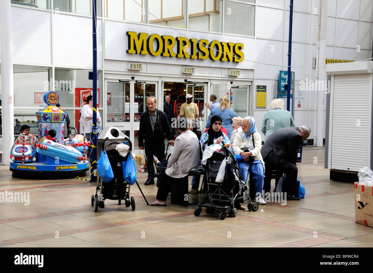 People sitting outside Morrisons Supermarket Holloway Islington London ...