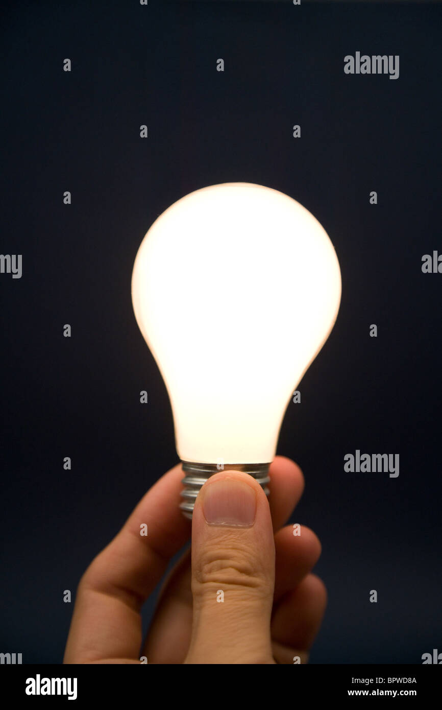 Hand holding a Bright Light Bulb, Concept of Inspiration, Ideas Stock ...