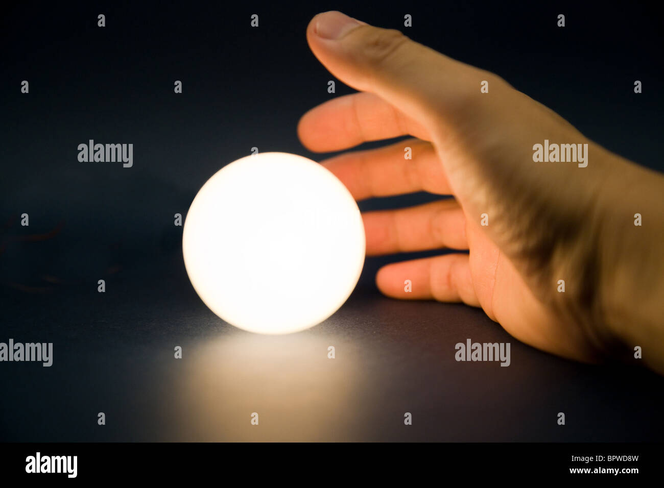 Hand touching a bright ball, Concept of magic Stock Photo - Alamy
