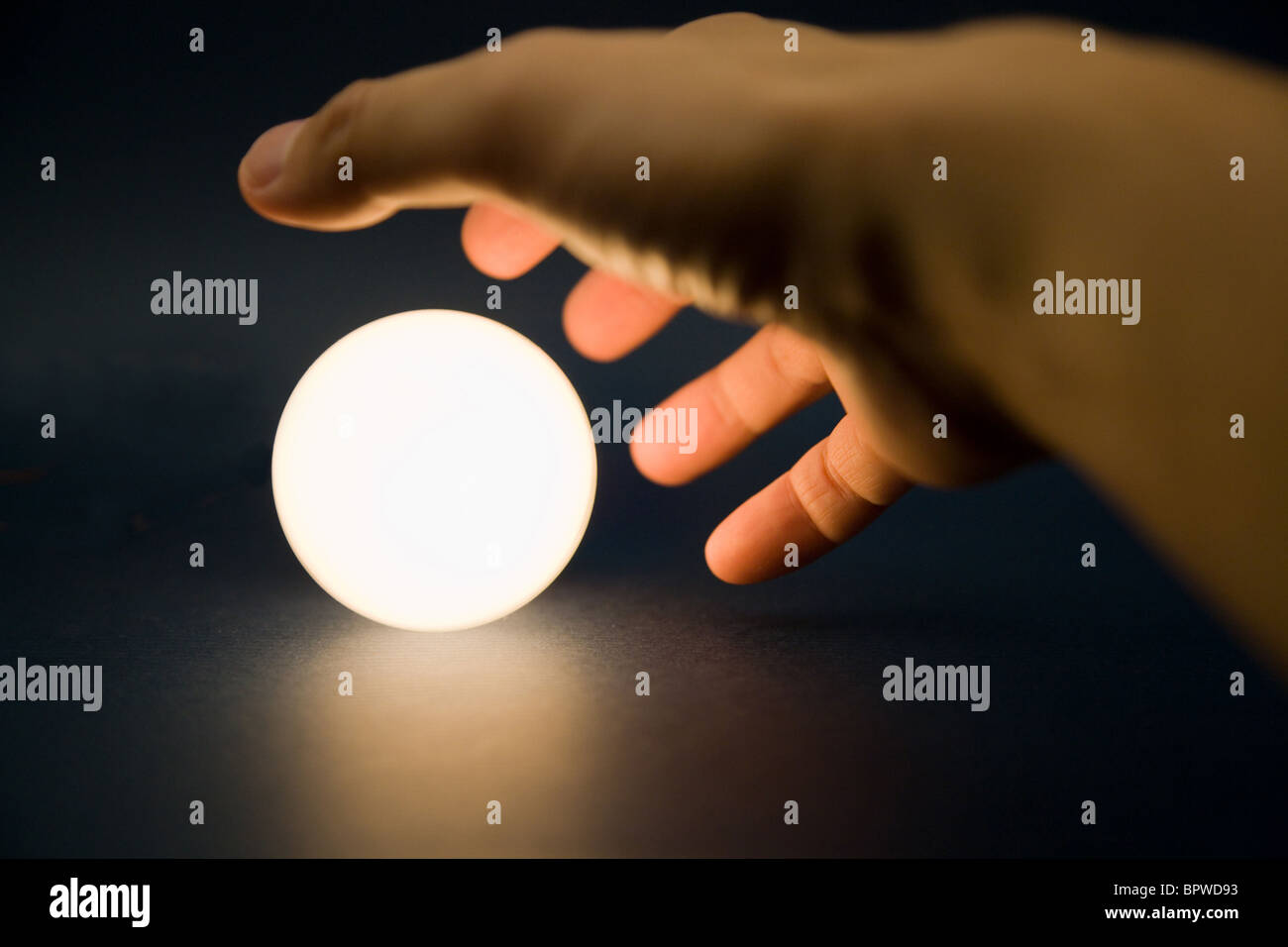 Hand touching a bright ball, Concept of magic Stock Photo - Alamy