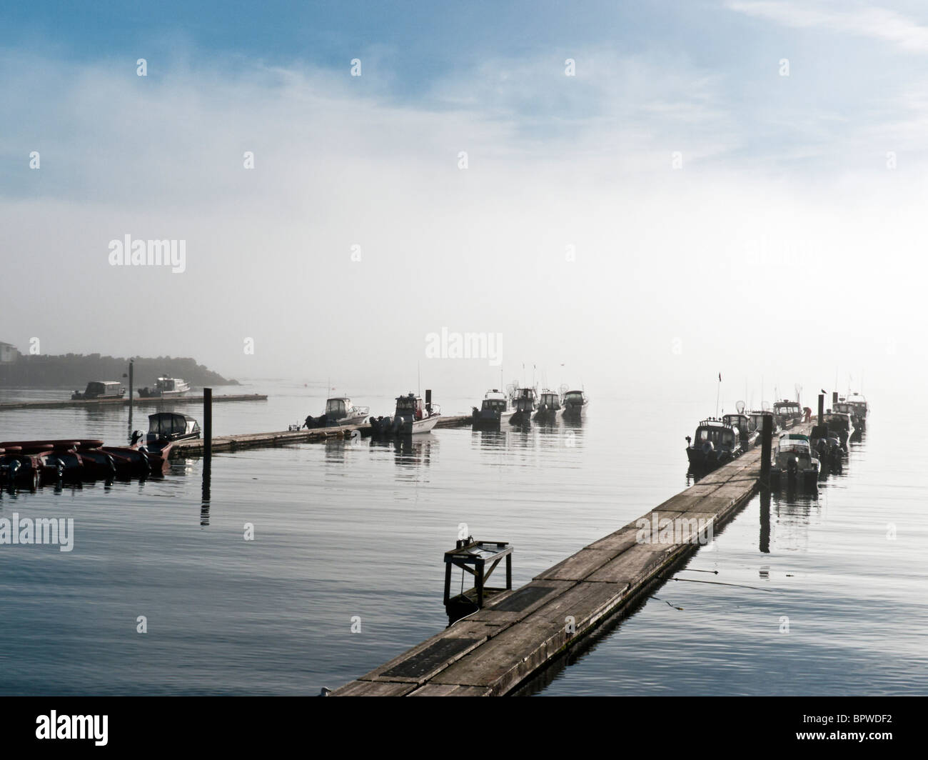 ghostly outline of floating finger piers with moored fishing boats ...