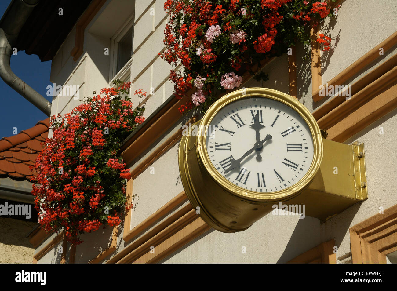 Clock with flowers on a house in the main square of Lubben Stock Photo ...