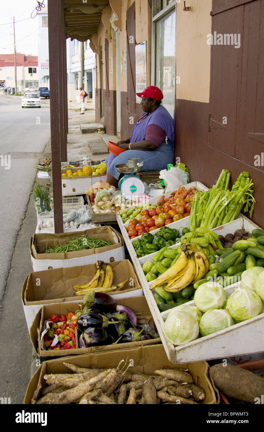 Market stall vendor shucking peas under Georgian balcony of ...