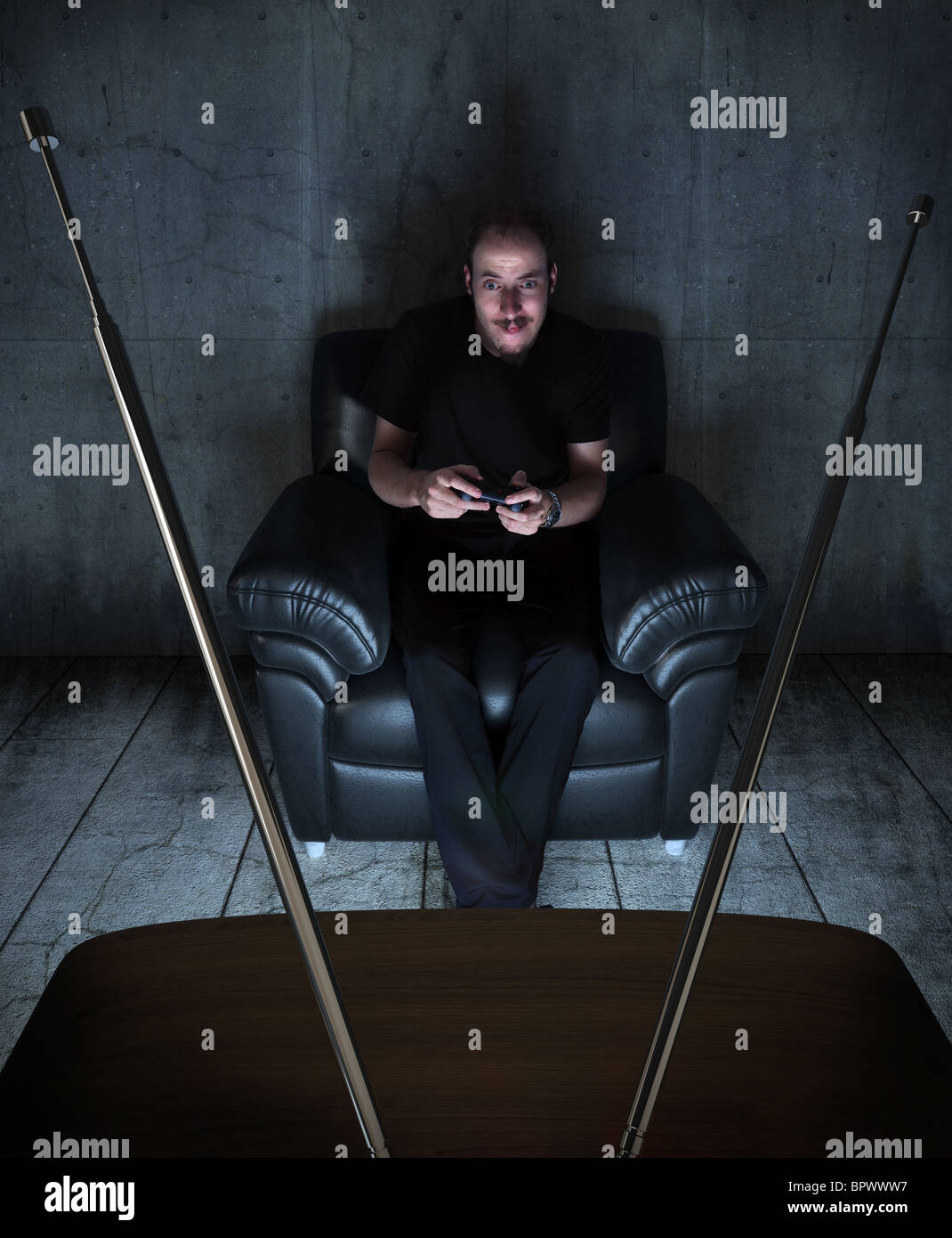 young adult playing video games in a grungy and dark room only ...