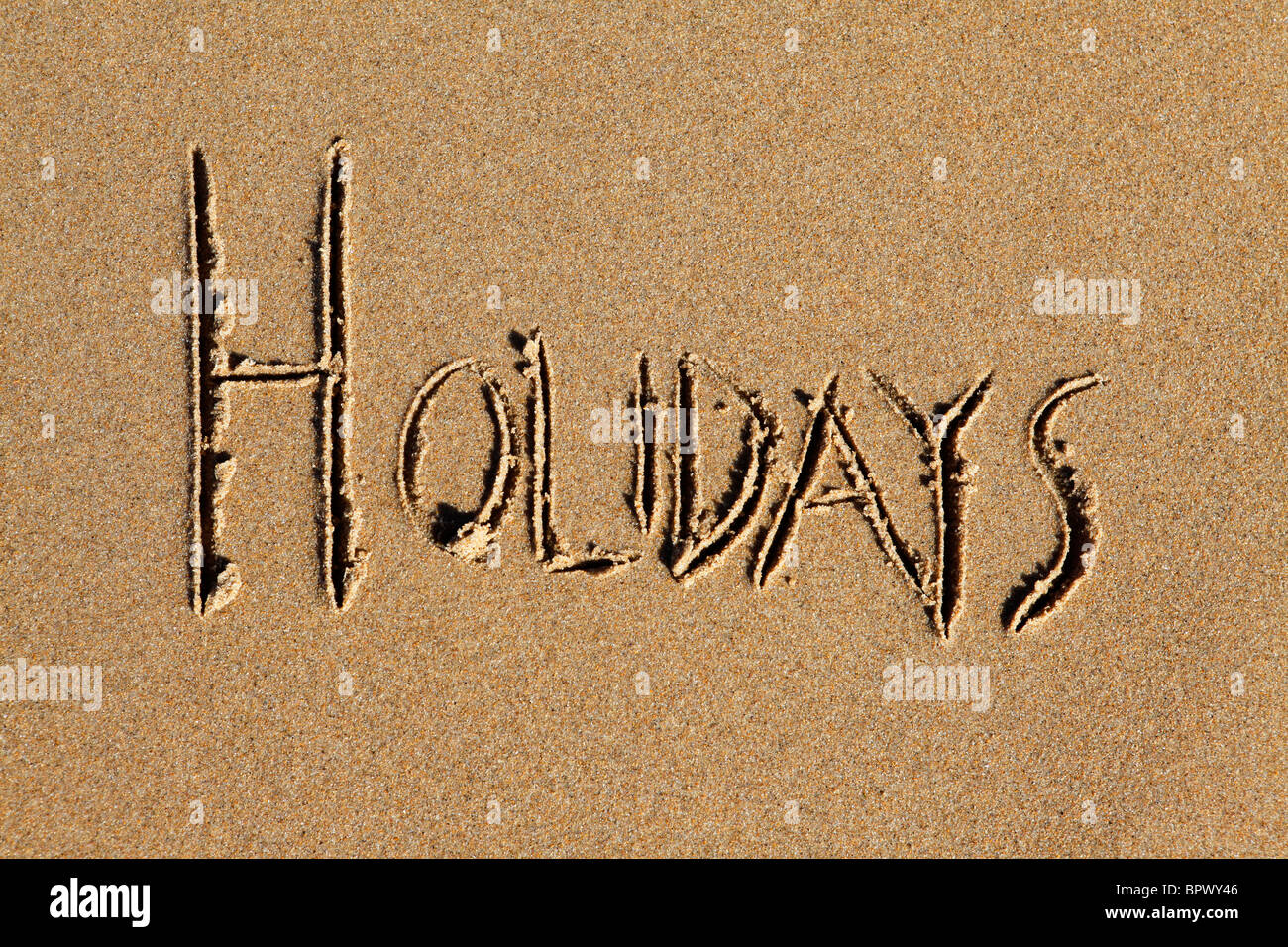 The words "holidays" is written on the golden sands of a beach Stock ...