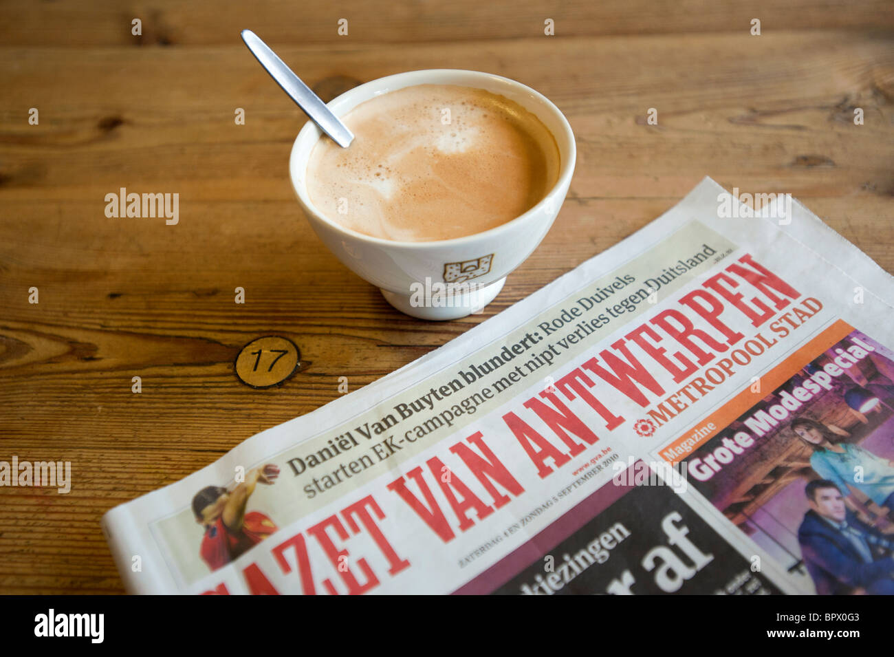 Detail of coffee and local newspaper in traditional bakers shop and ...