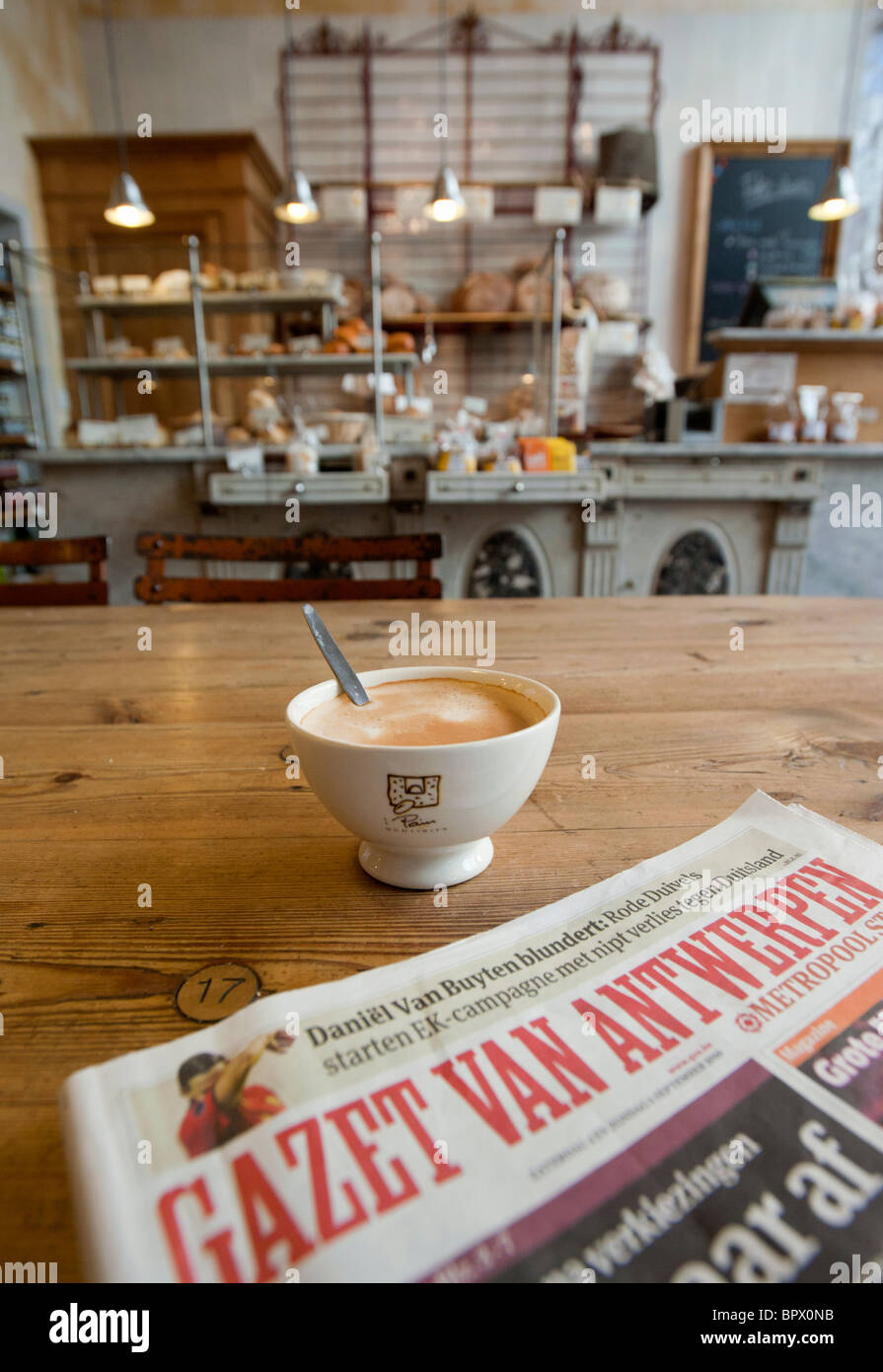 Detail of coffee and local newspaper in traditional bakers shop and ...
