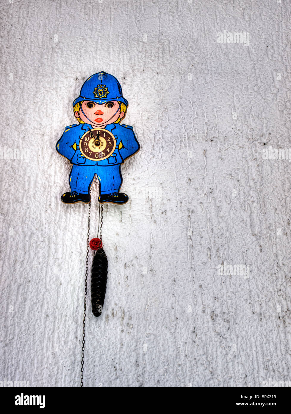 Clock with the figure of policeman on the old grungy wall may represent ...