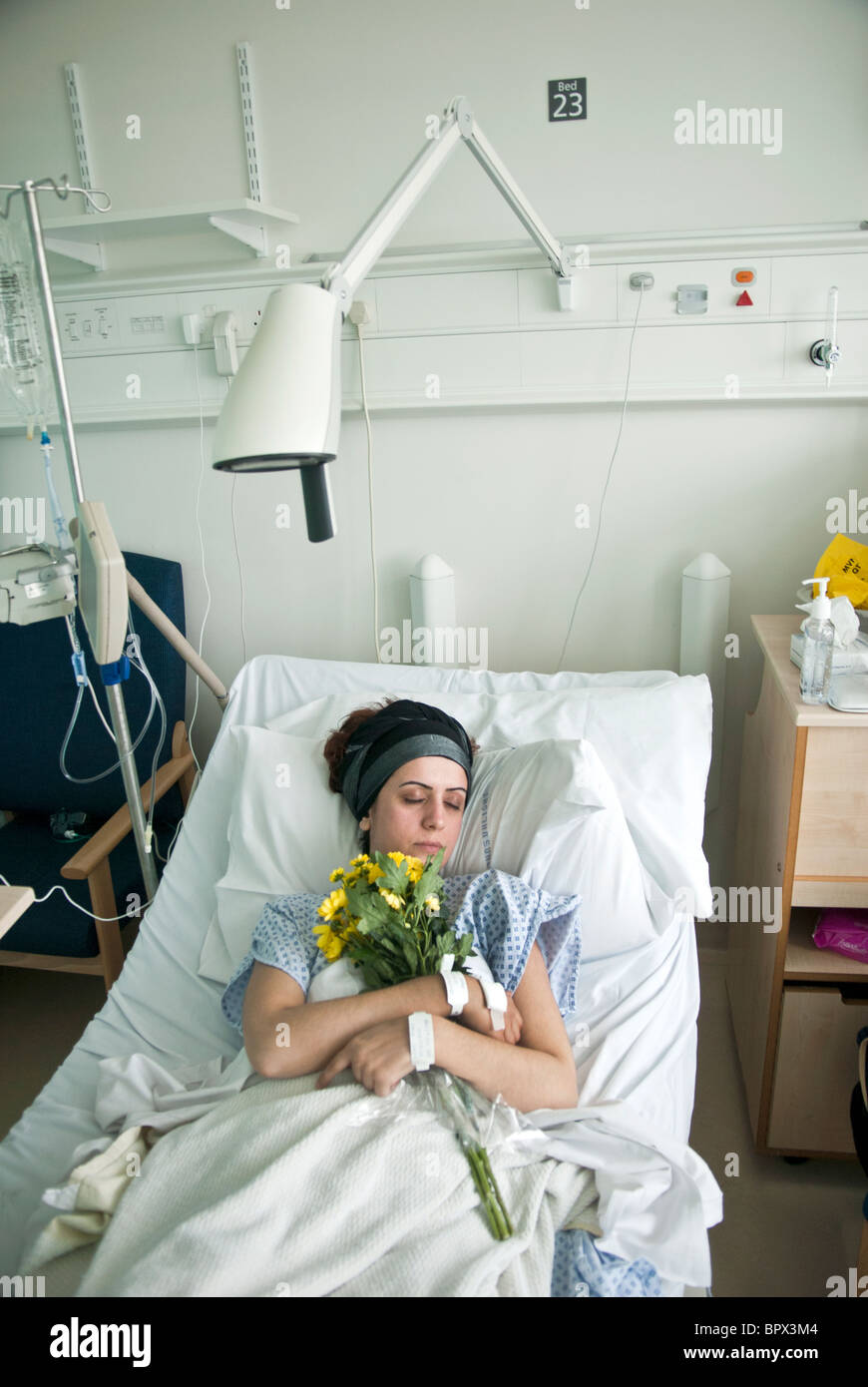 PATIENT HOLDING BUNCH OF FLOWER IN HER HOSPITAL BED SLEEPING Stock ...
